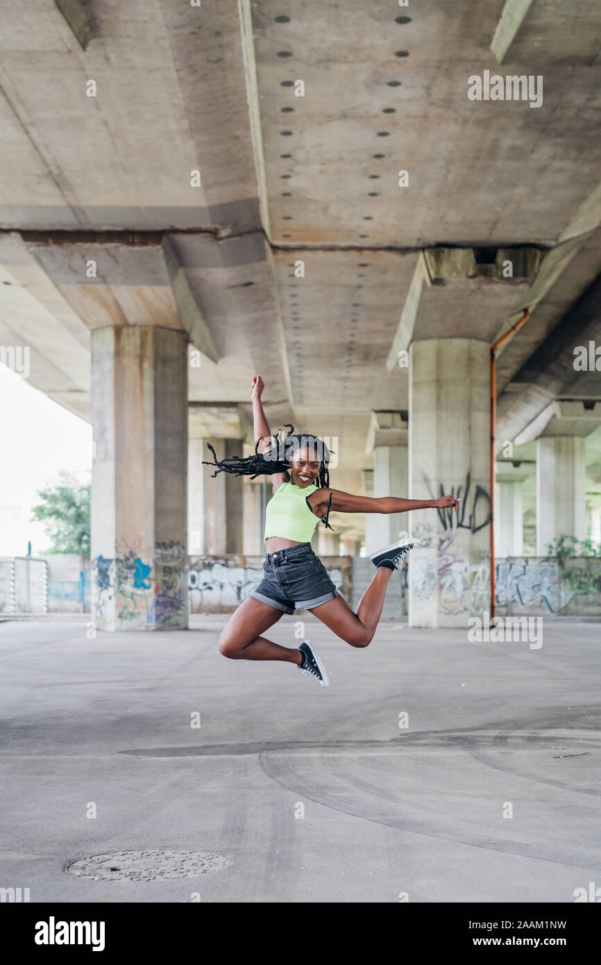 Woman jumping in mid air in city Stock Photo - Alamy
