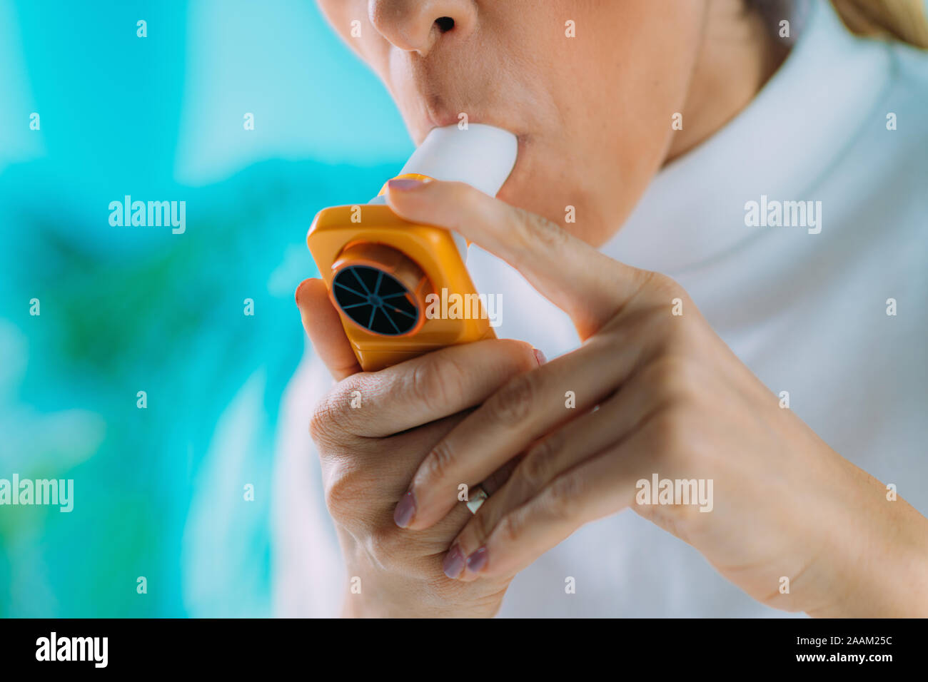 Woman using spirometer, measuring lung capacity and force expiratory ...