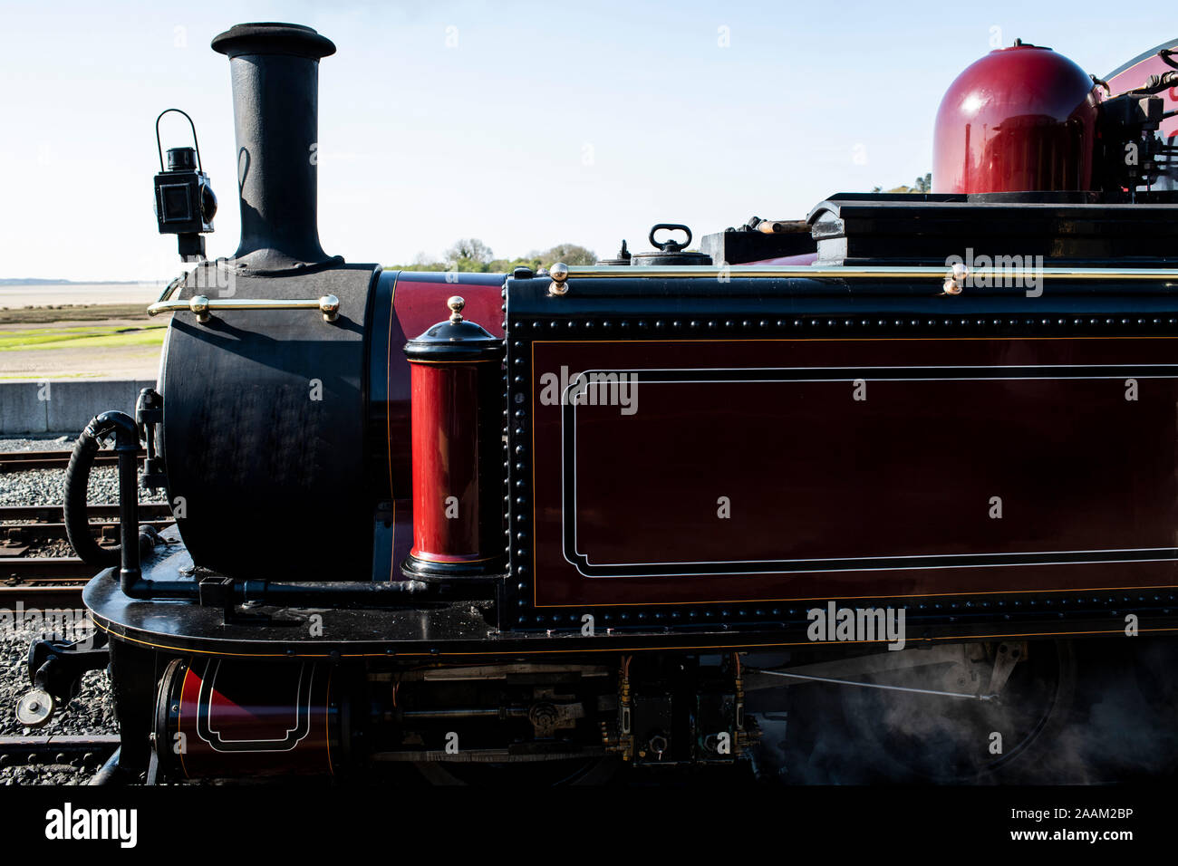 Steam train passing through seaside Stock Photo - Alamy