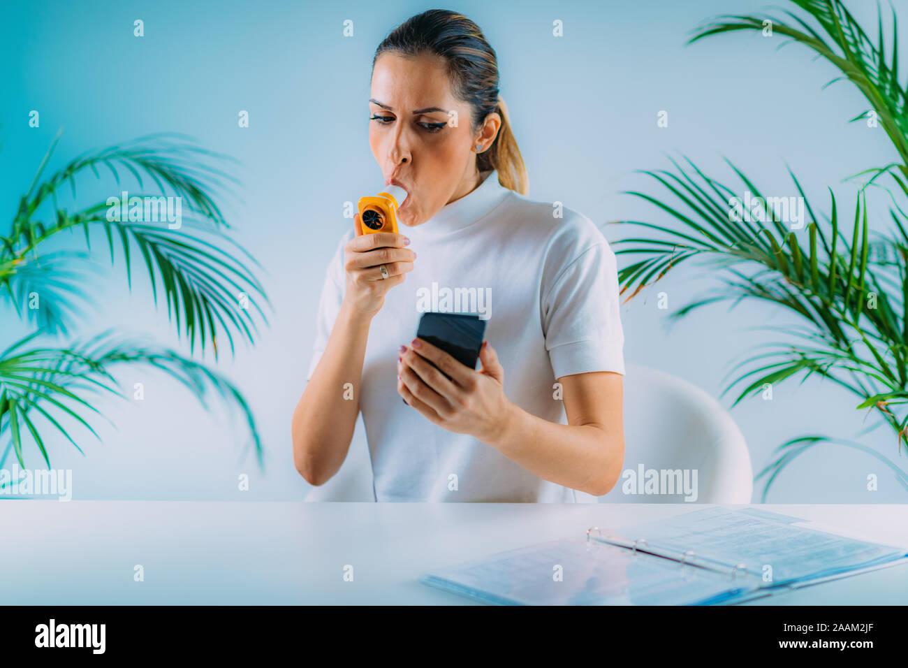 Woman using portable spirometer and a smart phone app Stock Photo - Alamy
