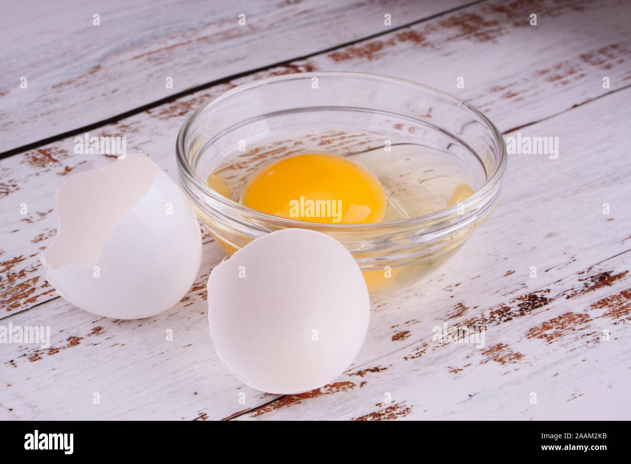 Fresh raw white eggs as ingredient in a small glass bowl place on white ...