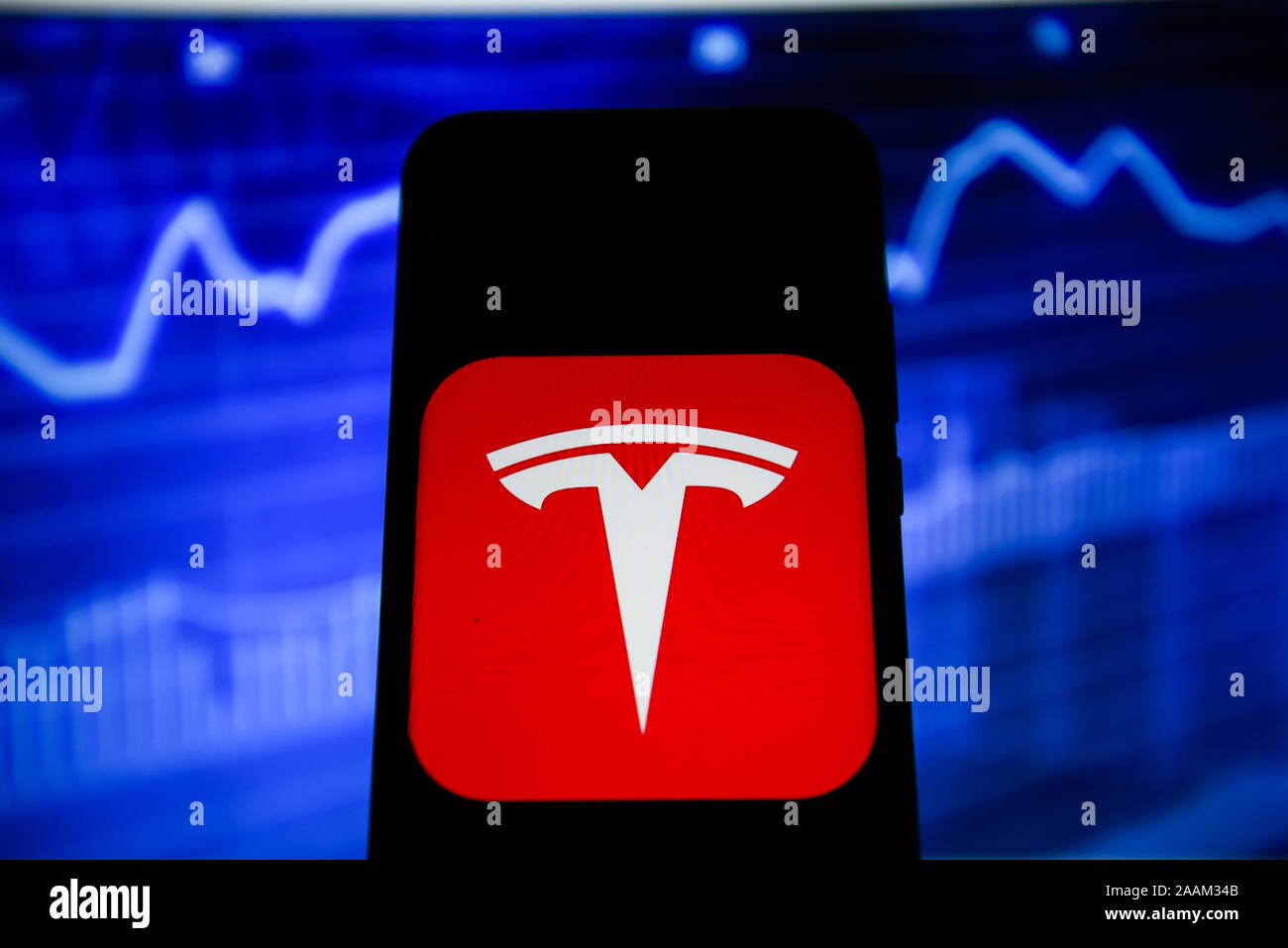 In this photo illustration a Tesla logo seen displayed on a smartphone ...