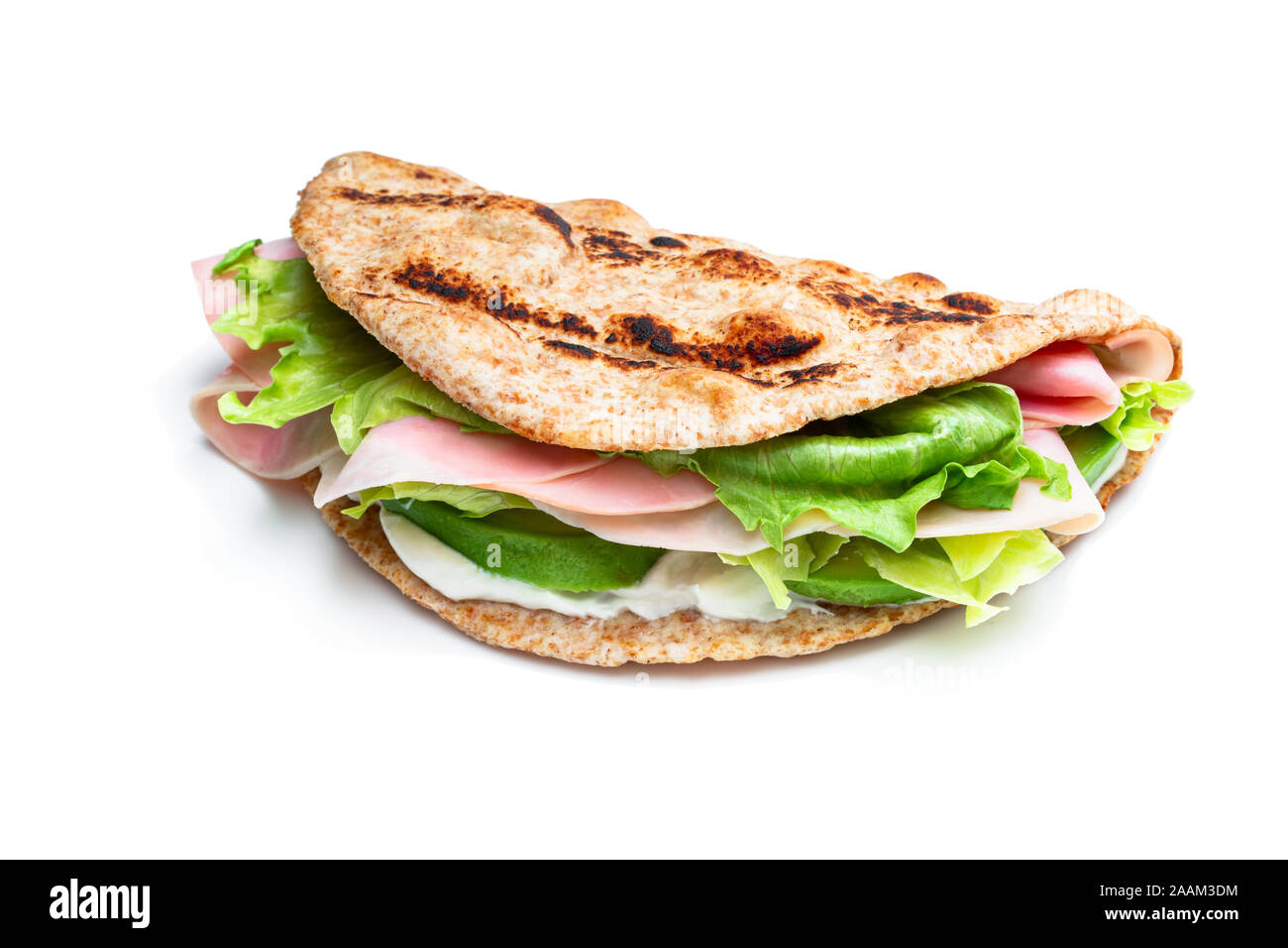 Folded wholemeal flatbread with ham and vegetables isolated on white ...