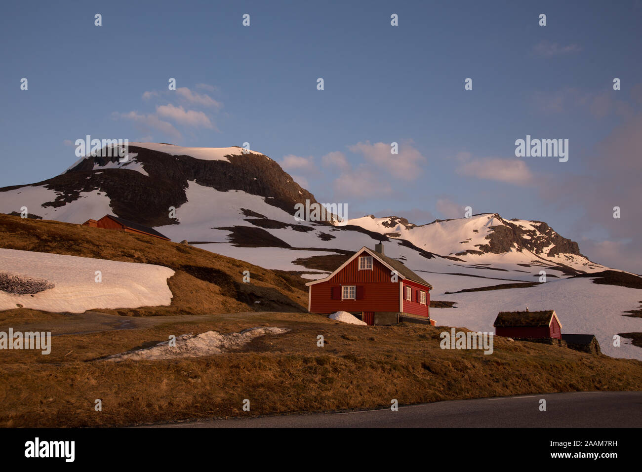 Red norwegian cabin at golden hour in front of a snowy mountain Stock ...