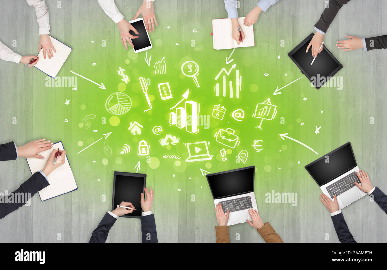 Group of people with devices in hands making reports together on laptop ...