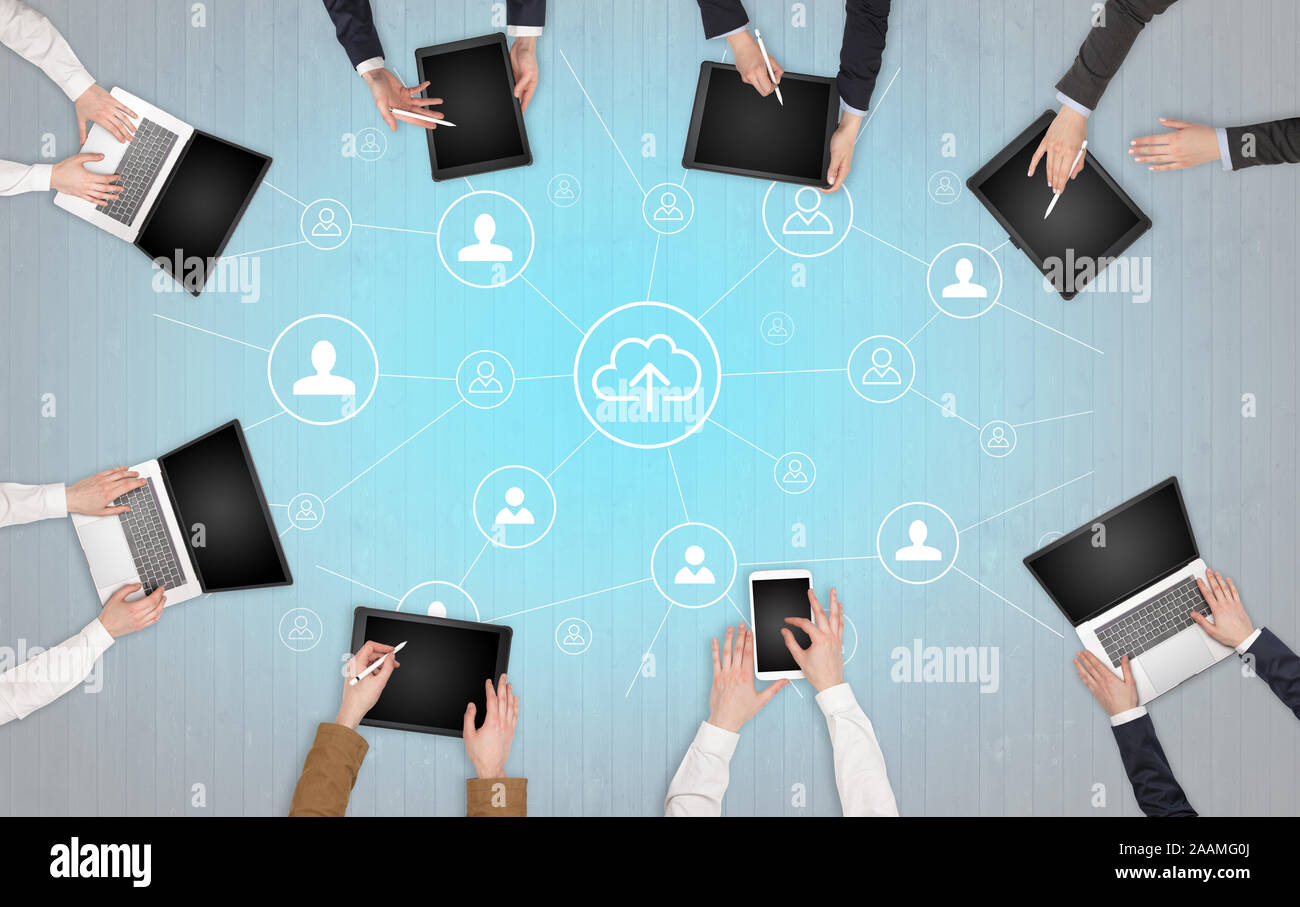 Group of people with devices in hands working in team on tablets ...