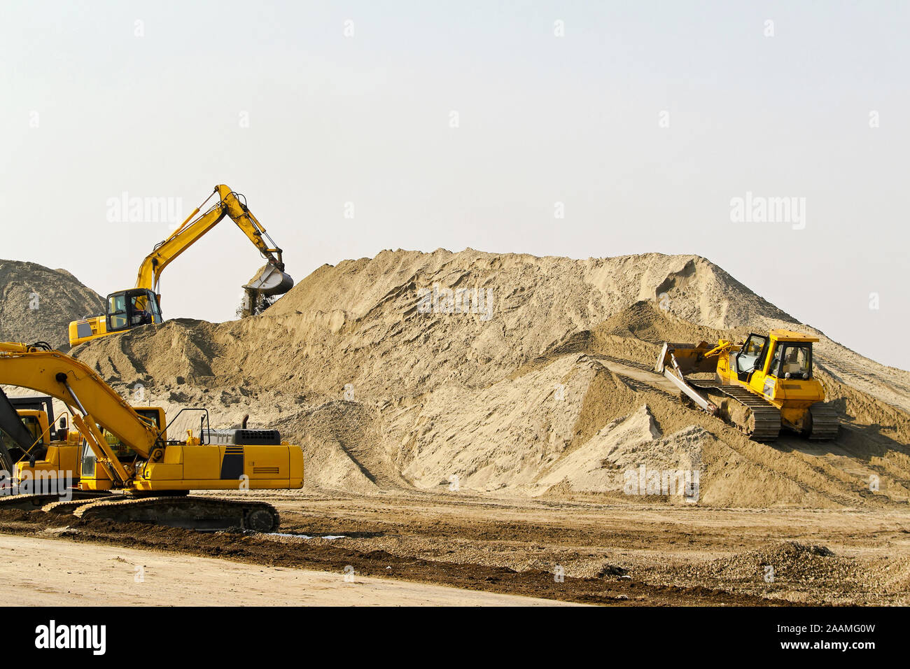 Excavator at big pile of sand at construction site hi-res stock ...