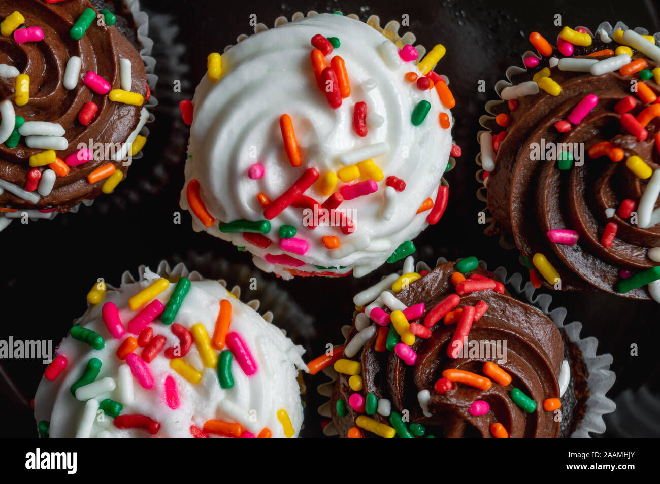Cupcakes closeup (flat layout) on a black surface Stock Photo - Alamy