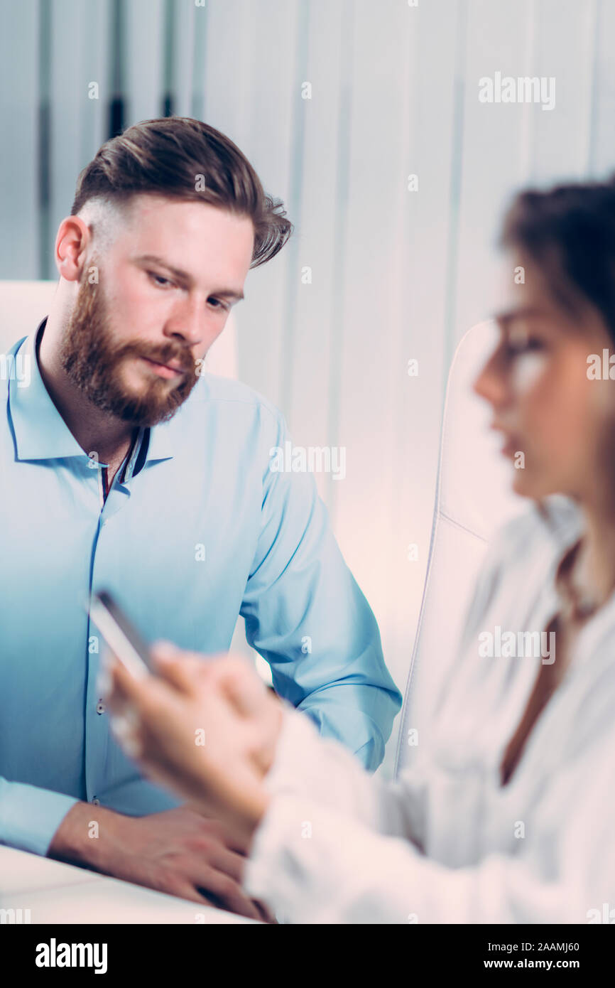 Business supervisor looking female employee's phone Stock Photo - Alamy