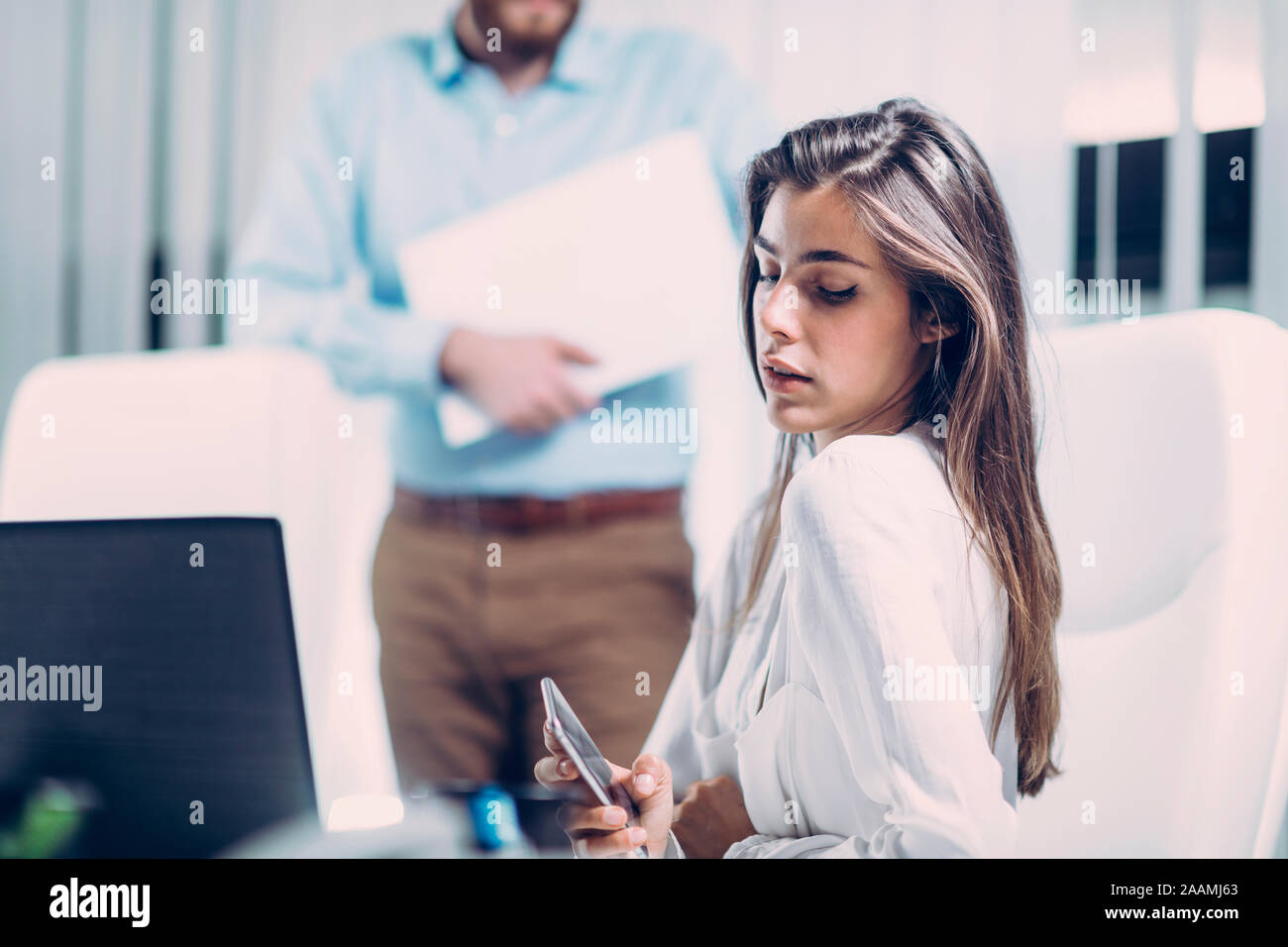 Business supervisor looking female employee's phone Stock Photo - Alamy