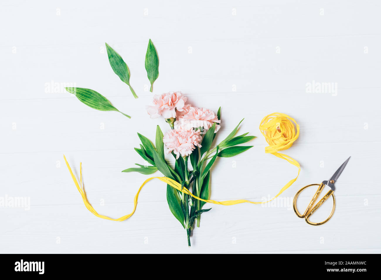 Flat lay composition process of making bouquet of flowers on white ...