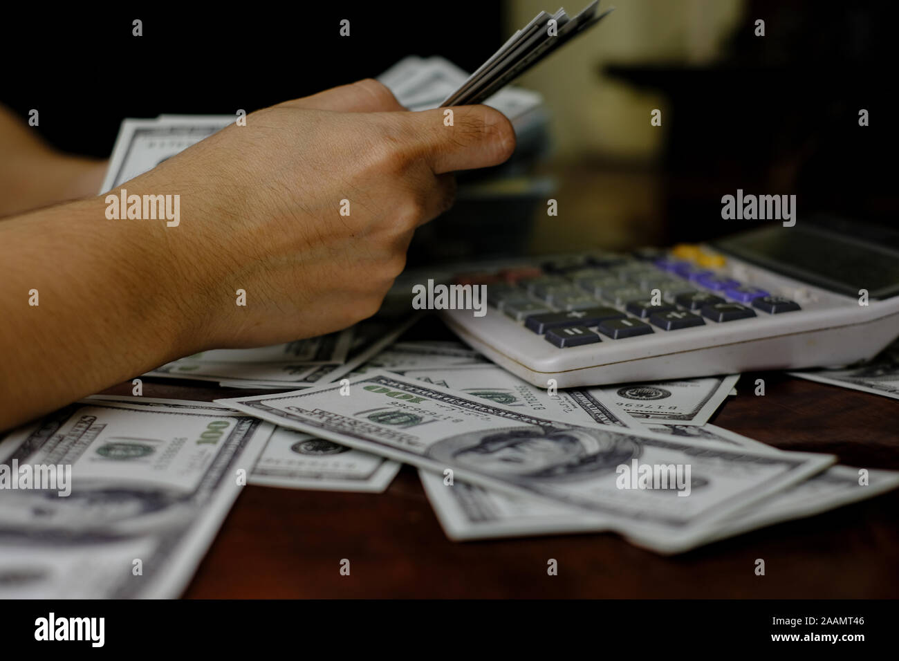 Businessmen women counting money on a stack of 100 US dollars banknotes ...