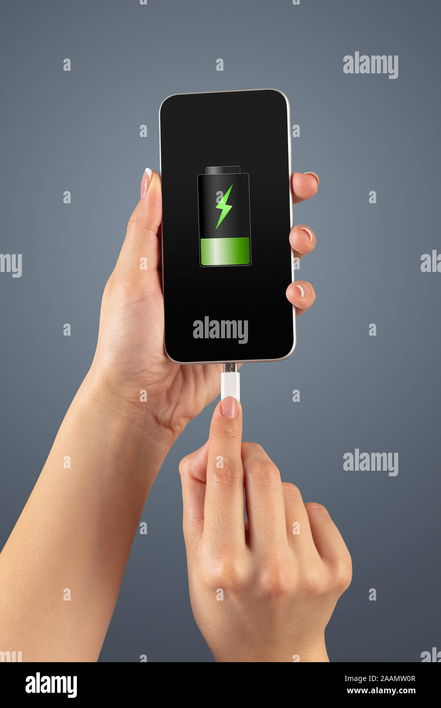 Elegant hand charging cellphone with low battery Stock Photo - Alamy