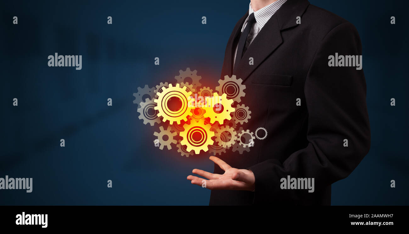 Hand holding gears in his hand Stock Photo - Alamy