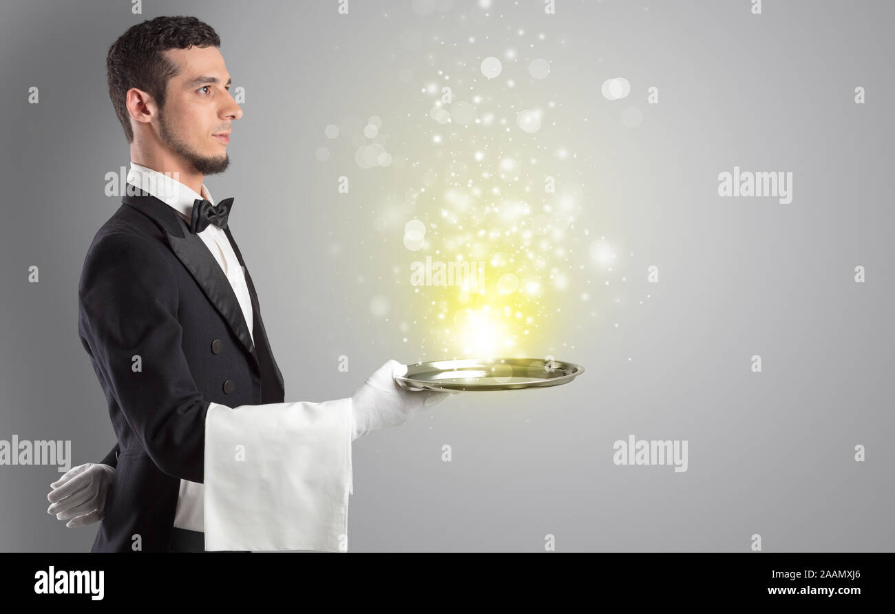Elegant young waiter serving mysterious light on tray Stock Photo - Alamy