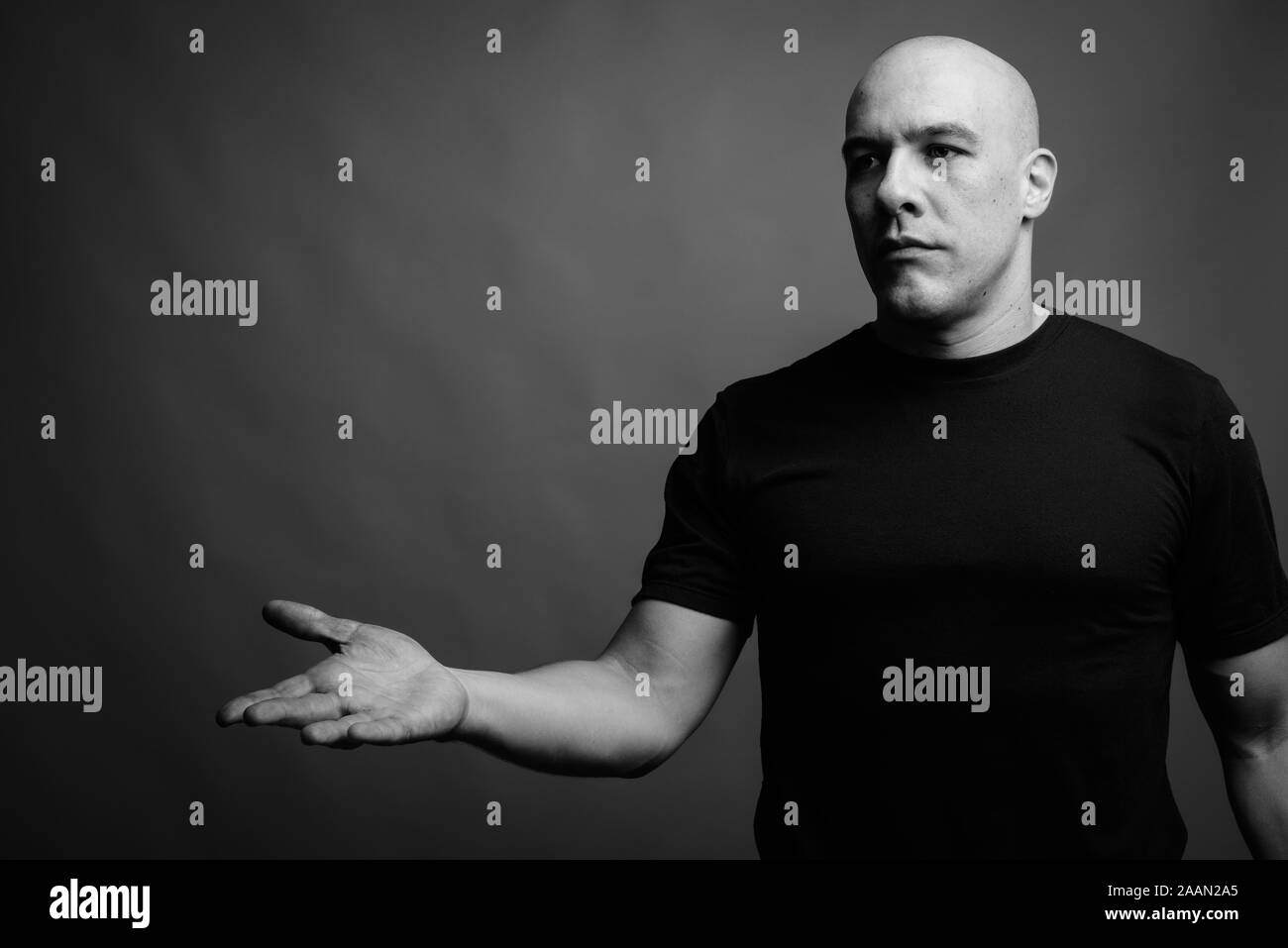 Handsome bald man against gray background in black and white Stock ...