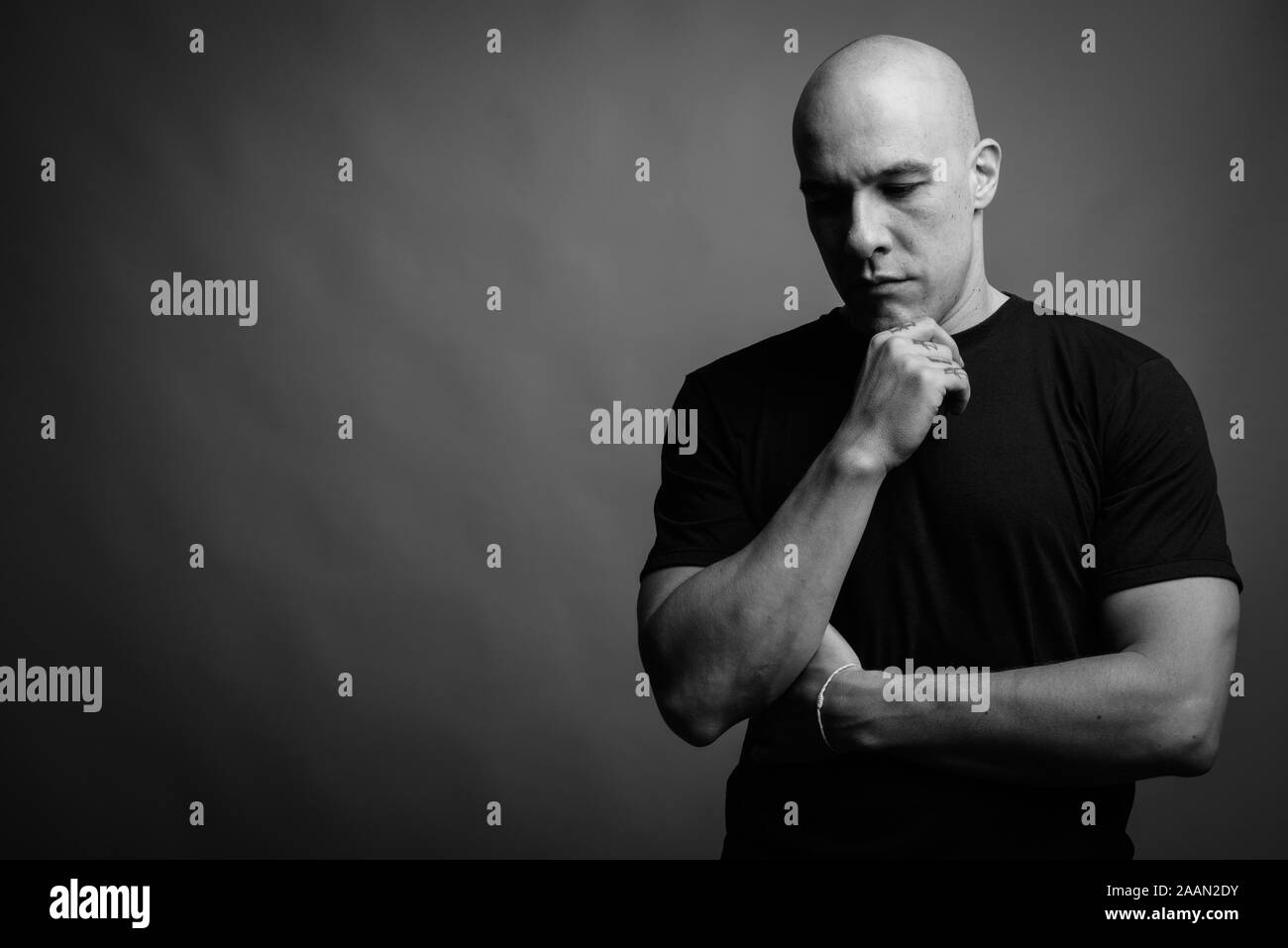 Handsome bald man against gray background in black and white Stock ...