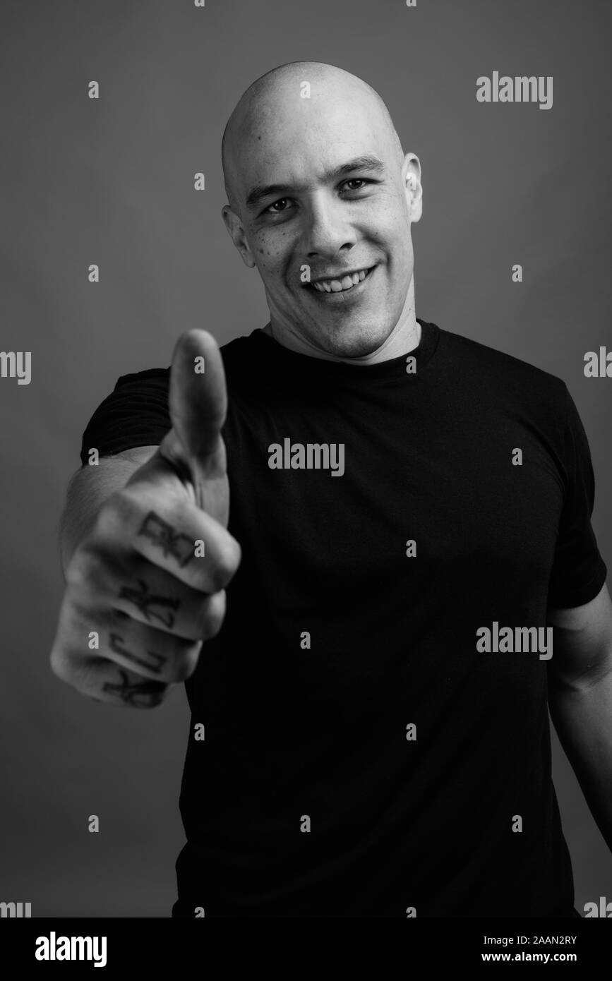 Handsome bald man against gray background in black and white Stock ...