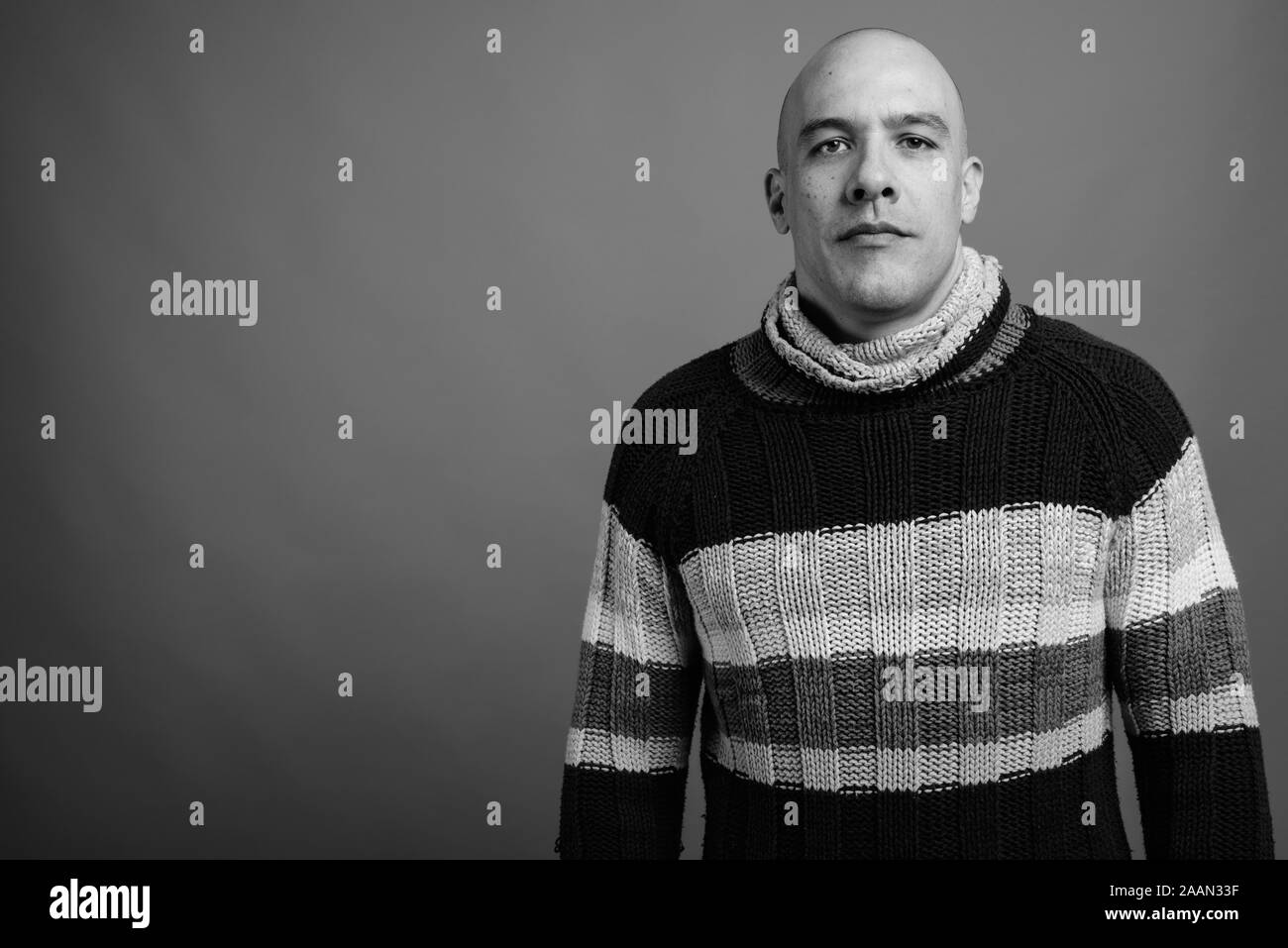 Handsome bald man against gray background in black and white Stock ...
