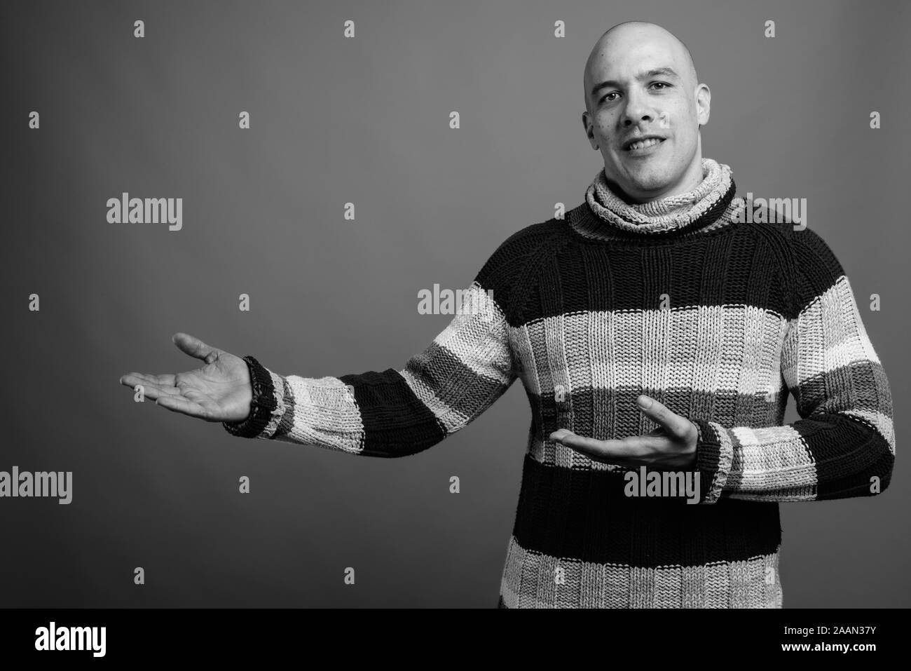 Handsome bald man against gray background in black and white Stock ...