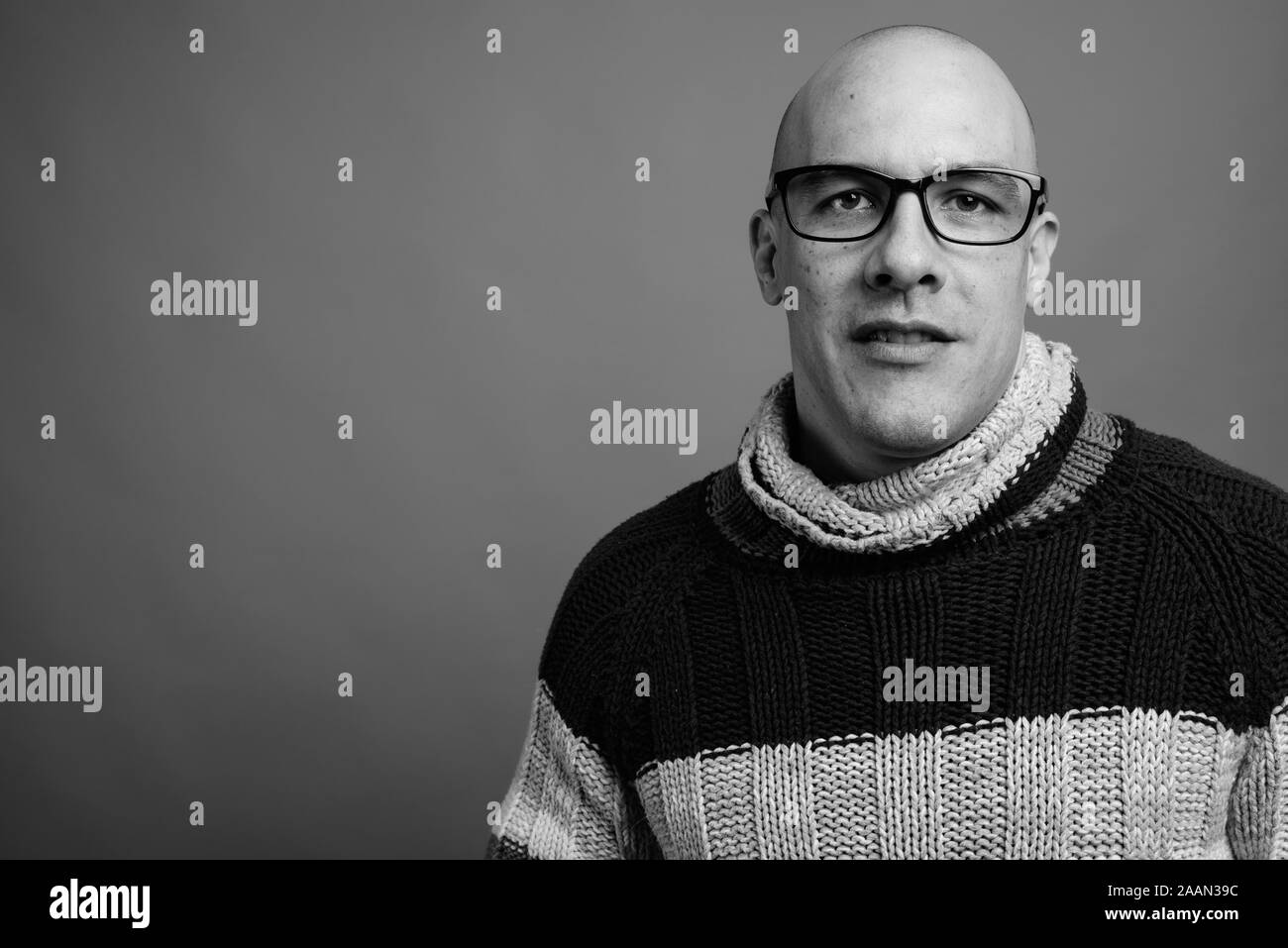Handsome bald man against gray background in black and white Stock ...