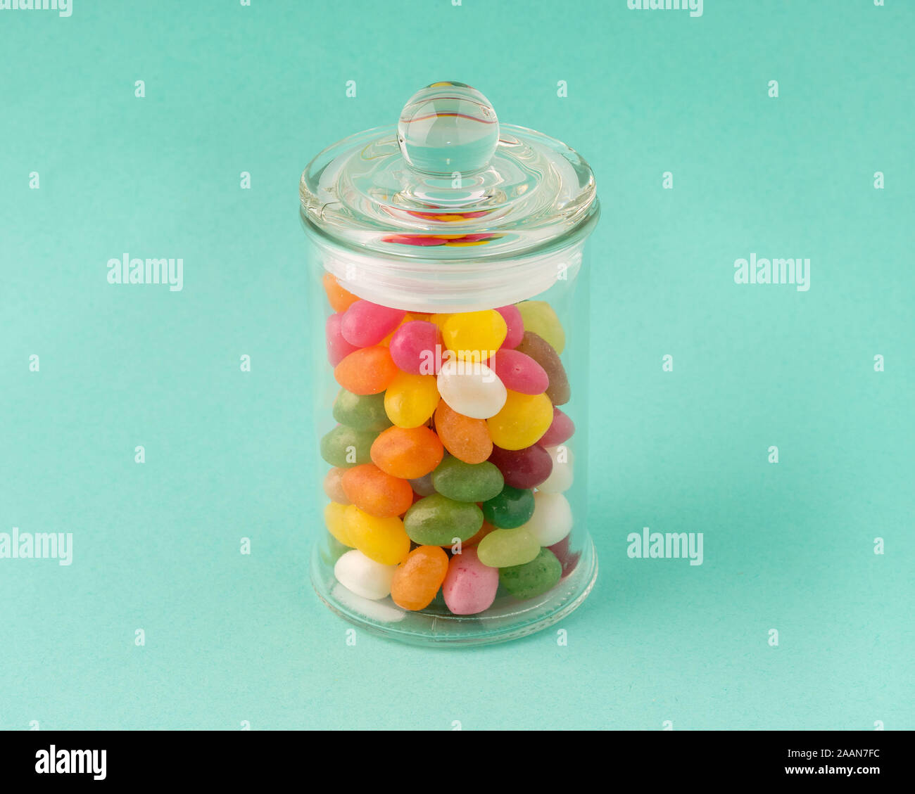glass jar with sweets, candy on a turquoise background Stock Photo - Alamy
