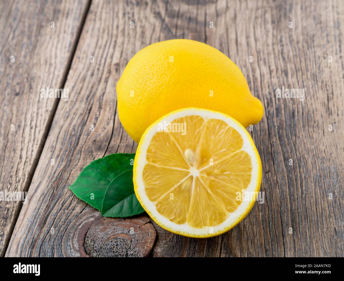 fresh lemon and cut off half on wooden old table, side view Stock Photo ...