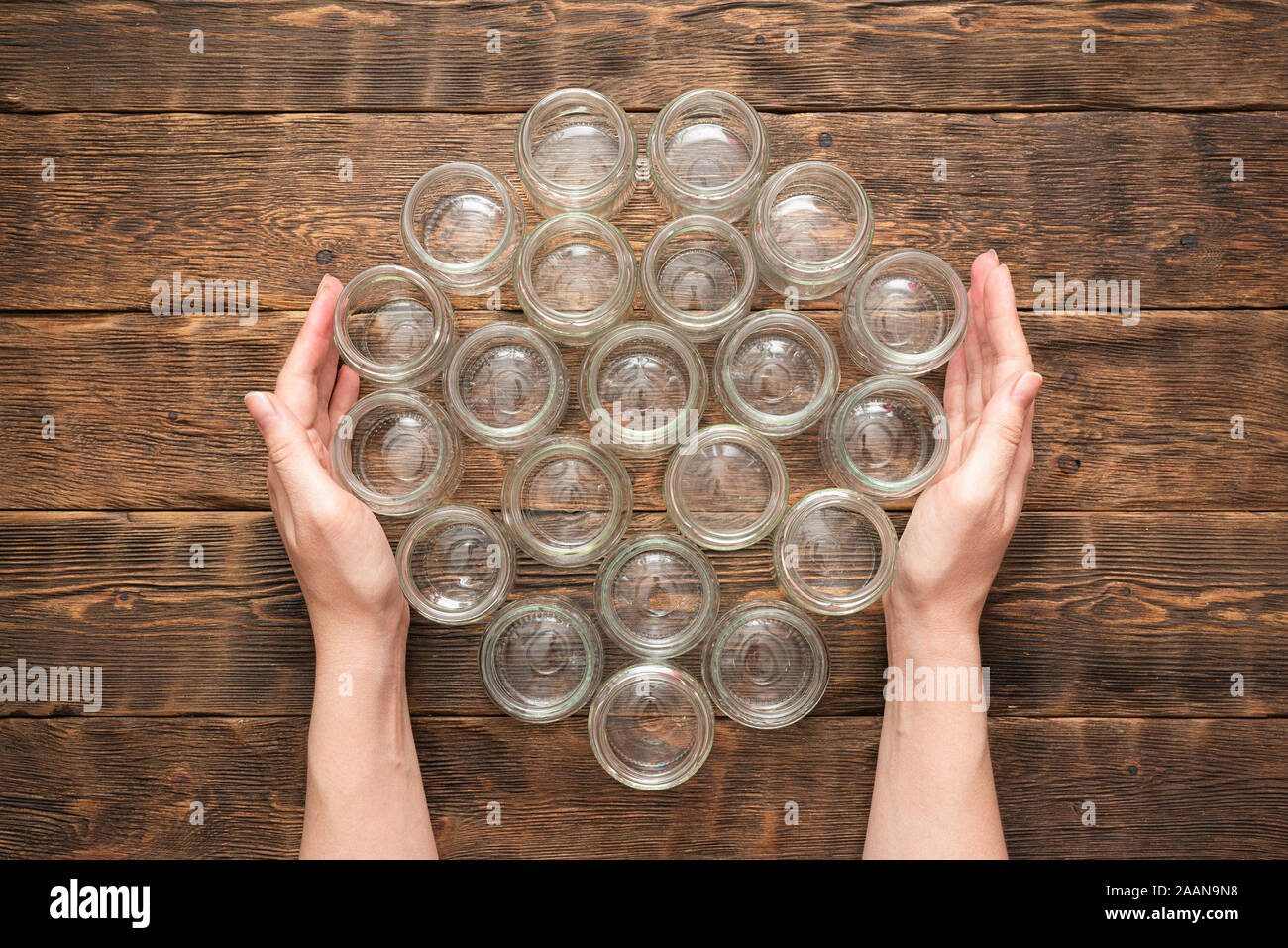 Woman hands and empty glass jars from baby food on the wooden table ...