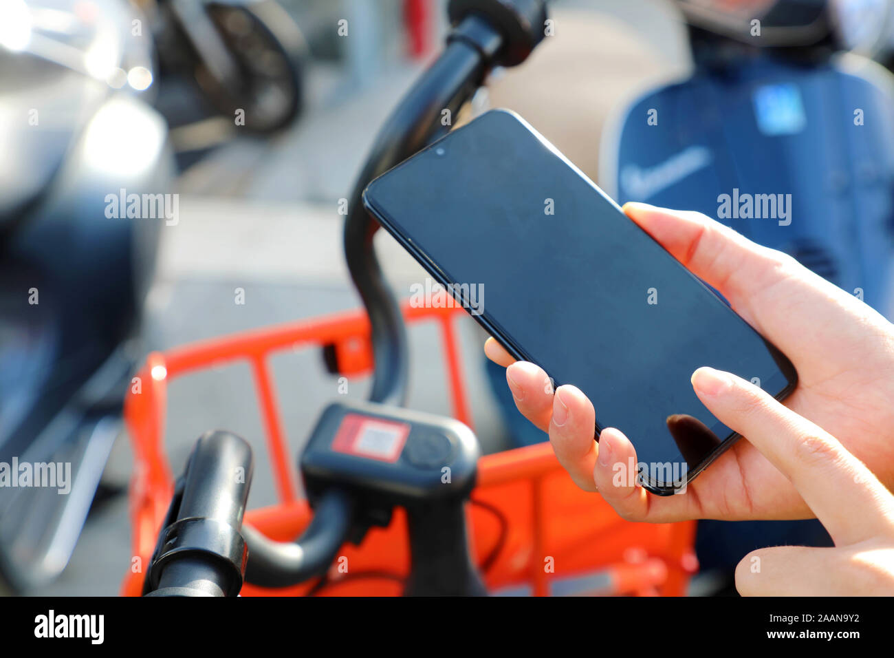 Shared bikes. Hand using smartphone scanning the QR code of shared bike ...