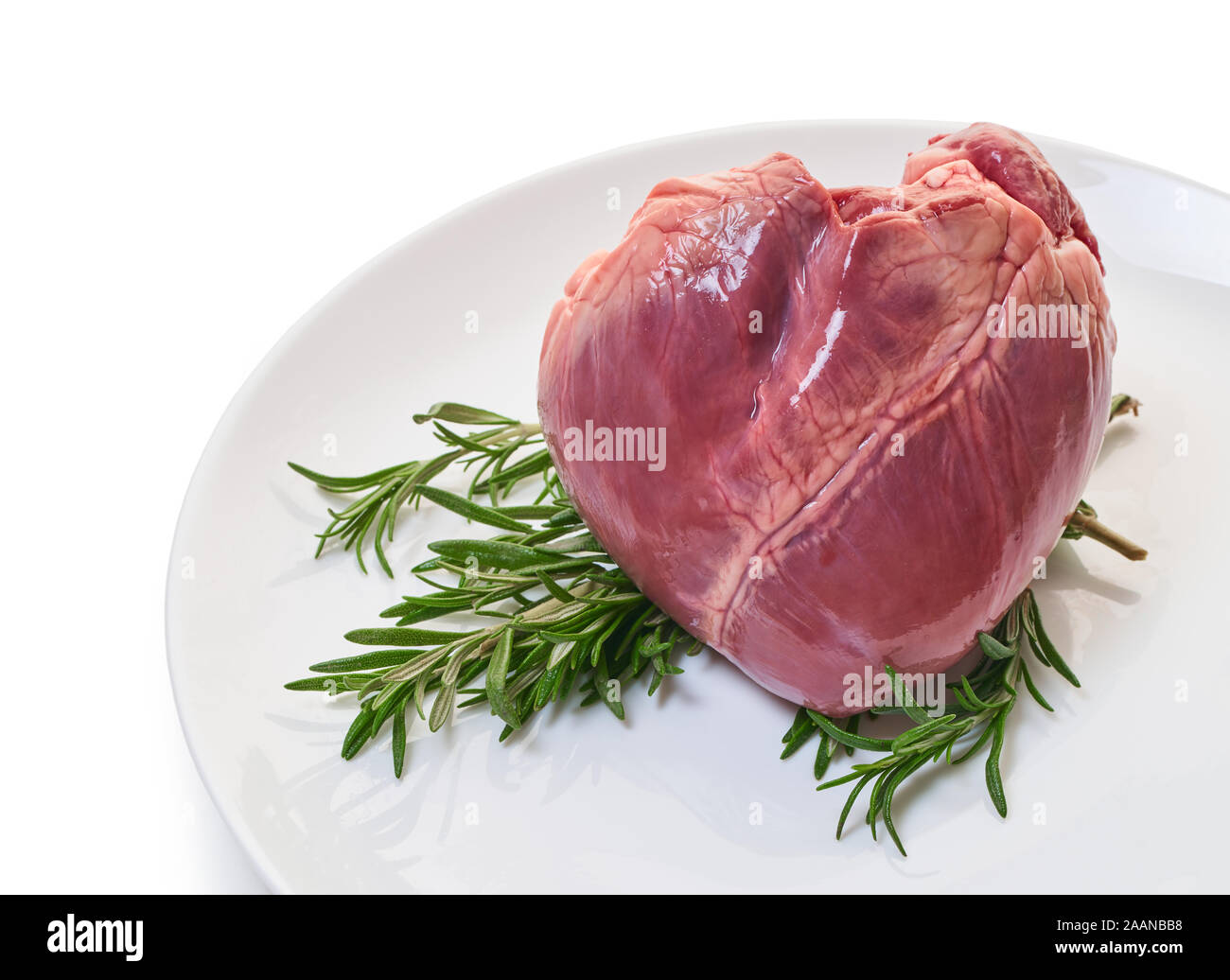 raw meat, beef heart with rosemary, white background Stock Photo - Alamy
