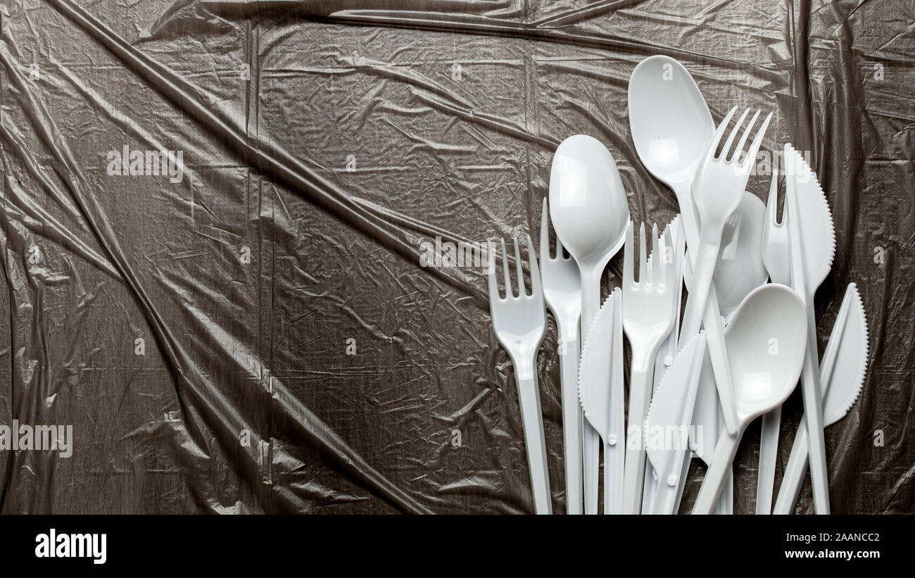 Plastic cutlery, forks, spoons and knives. Pollution of the environment ...