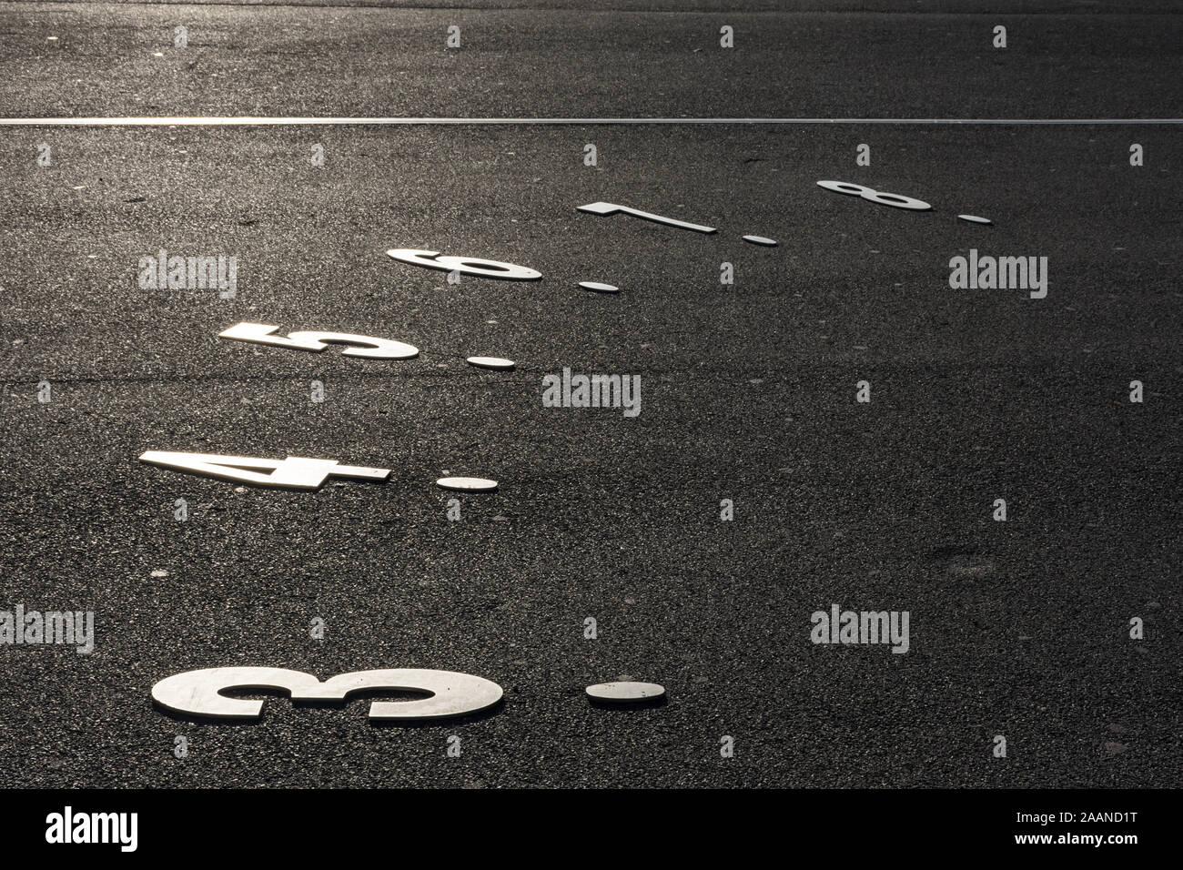Metal numbers on the stone floor Stock Photo - Alamy