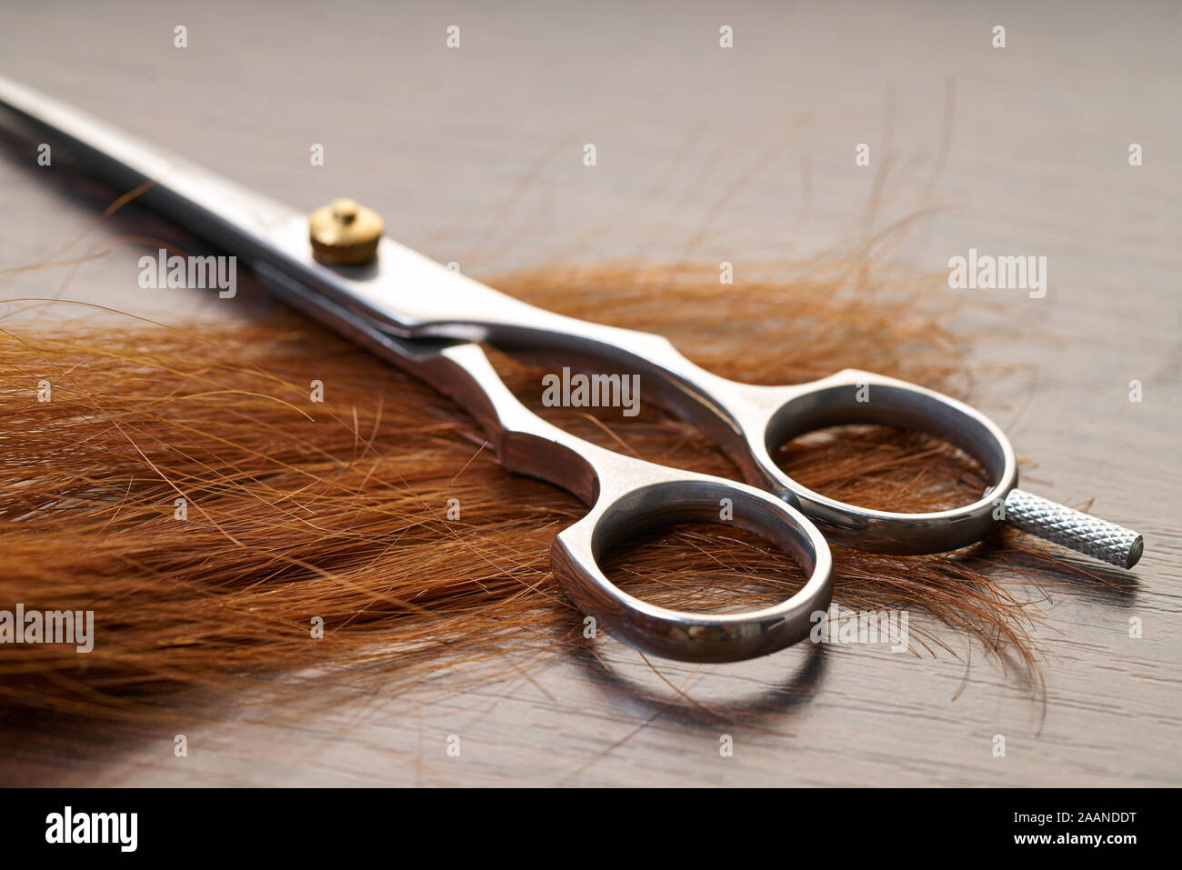 scissors with a lock of hair on wooden background Stock Photo - Alamy