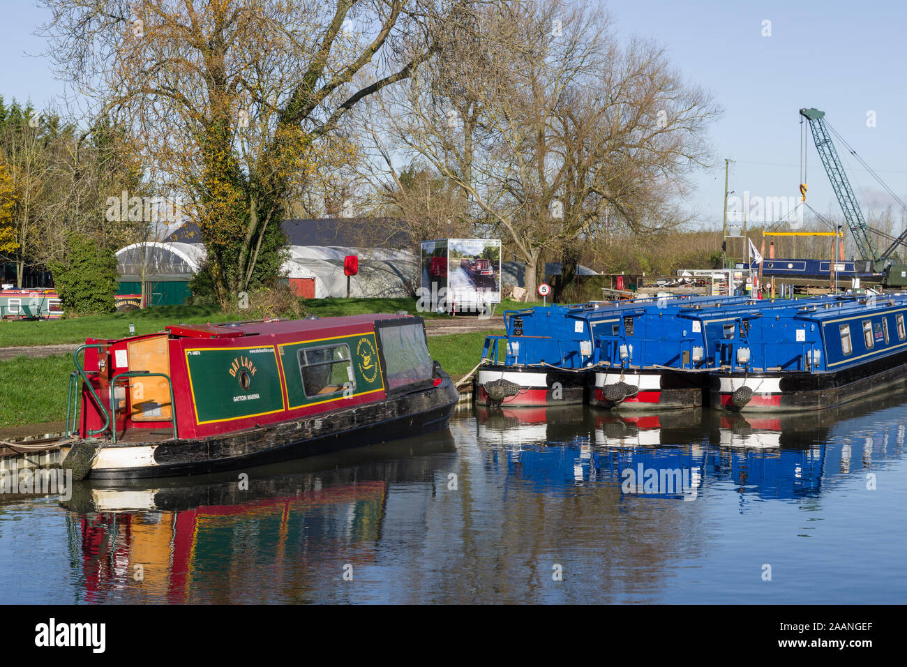 Colourful narrowboats moored on the Grand Union canal at Gayton Marina ...
