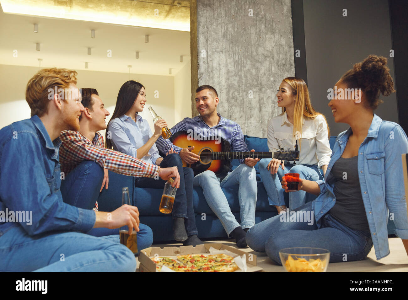Group of friends having party indoors fun together guy playing song ...