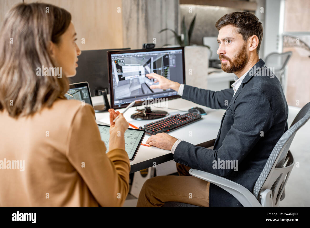 Two creative office employees making interior design on the computer ...