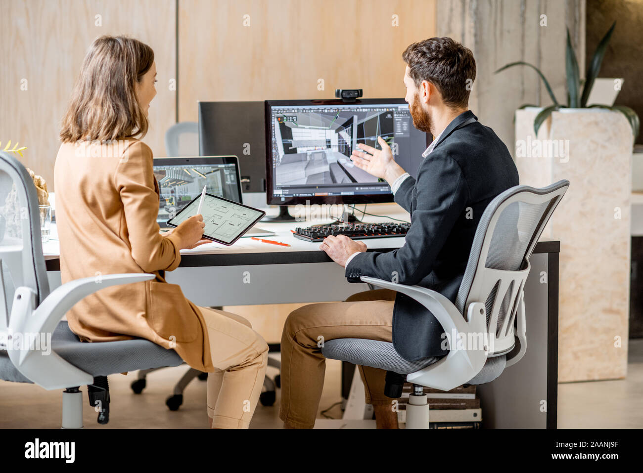 Two creative office employees making interior design on the computer ...