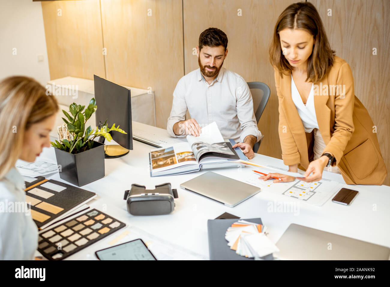 Colleagues doing teamwork in designing hi-res stock photography and ...