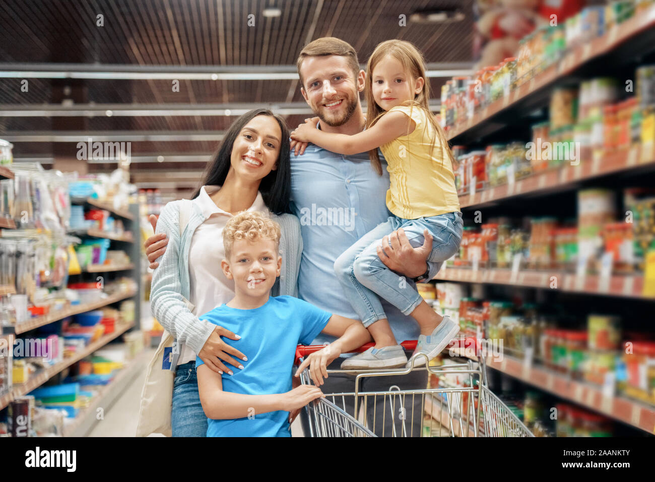 Daily Shopping. Family of four in the supermarket with cart parents ...