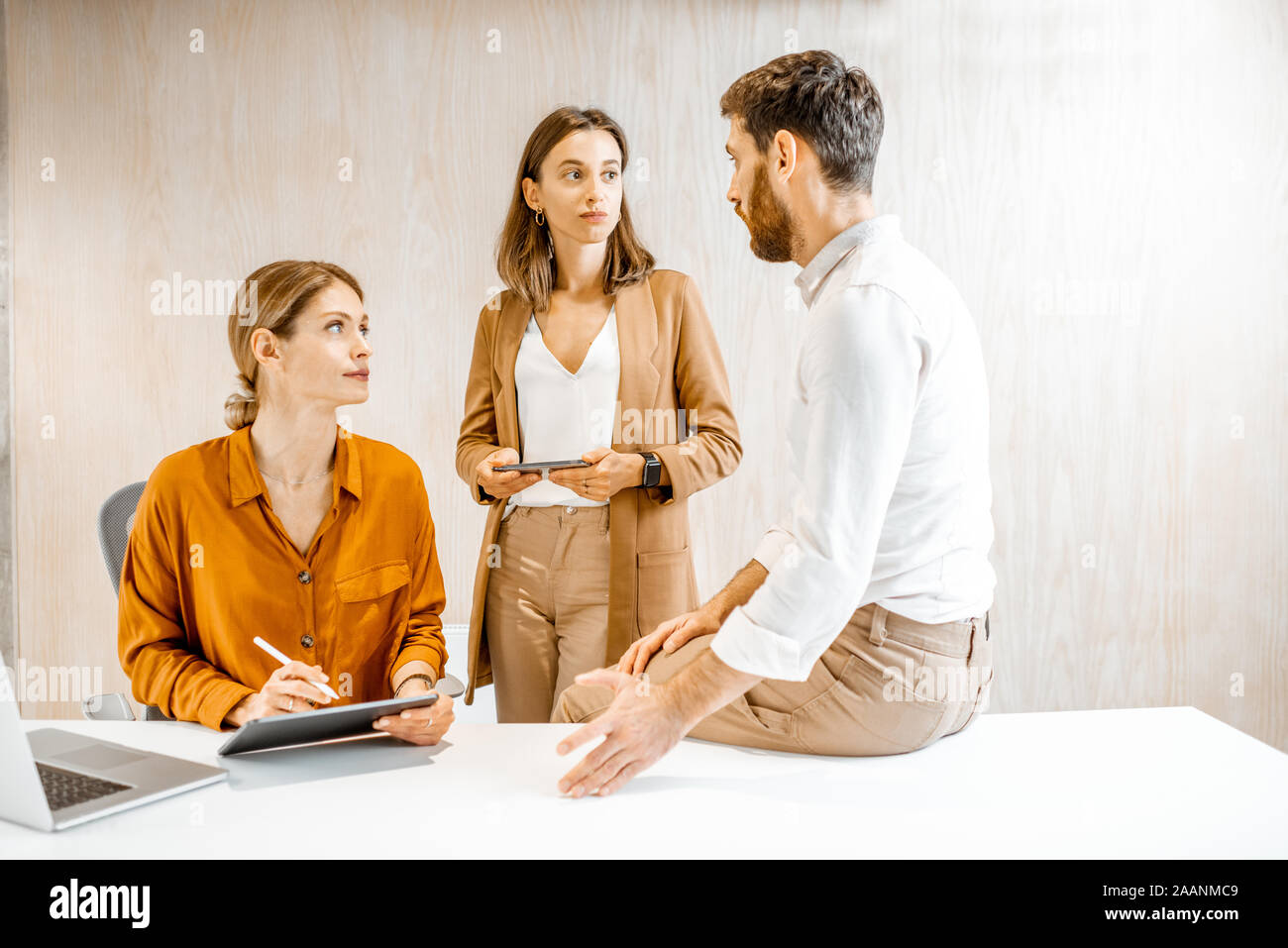 Office employees having some informal conversation at the workplace in ...