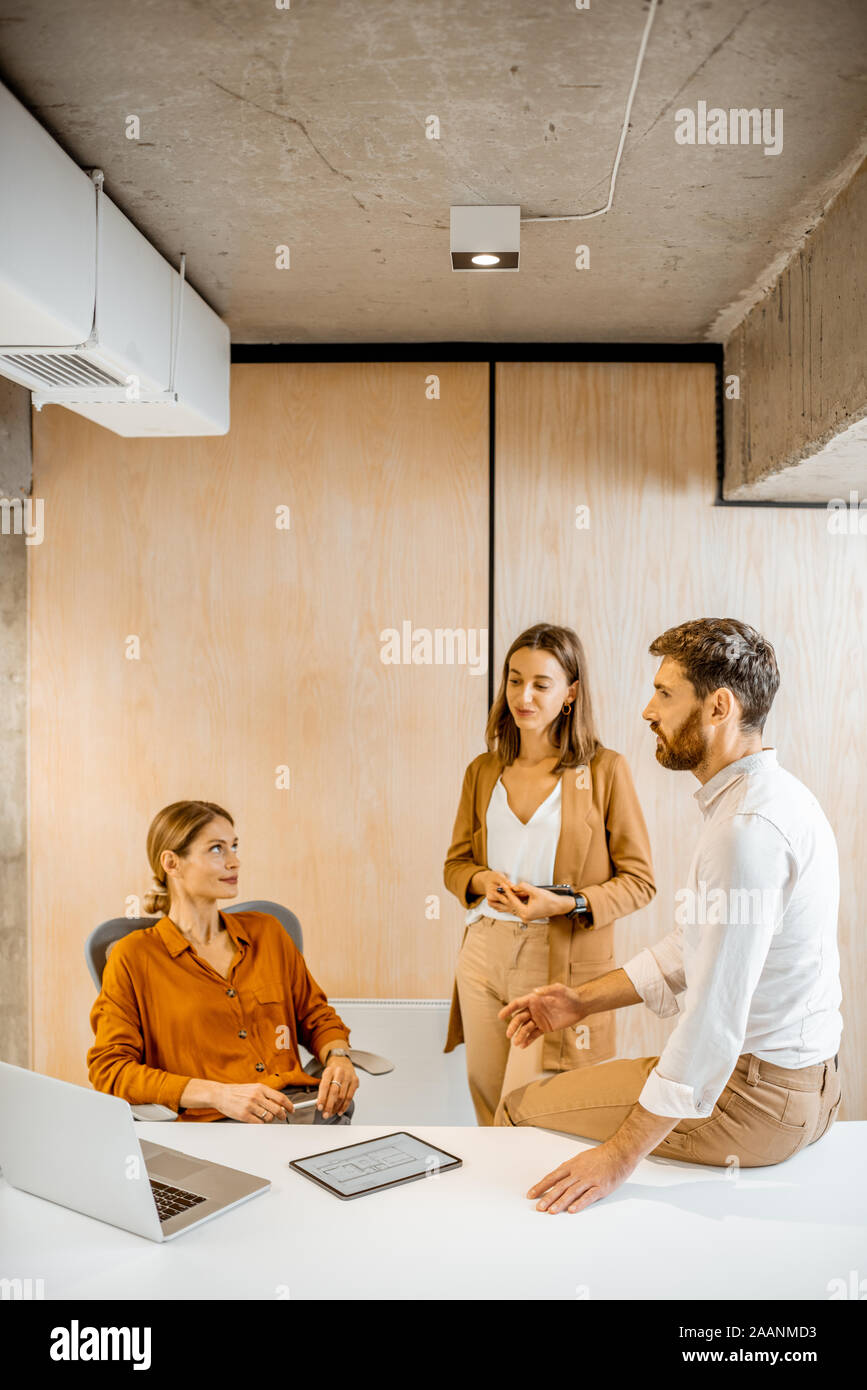 Office employees having some informal conversation at the workplace in ...