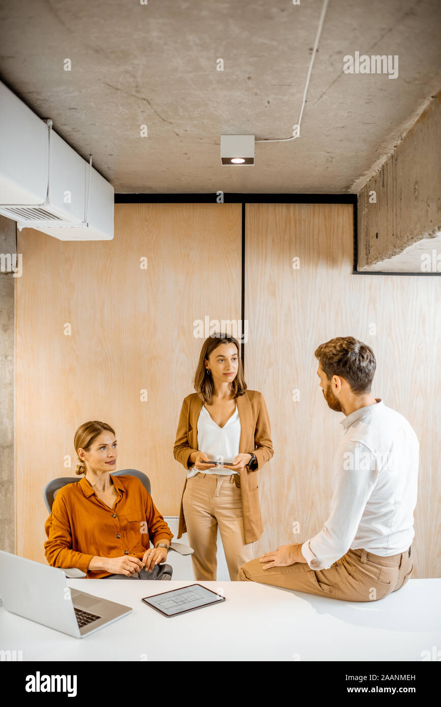 Office employees having some informal conversation at the workplace in ...