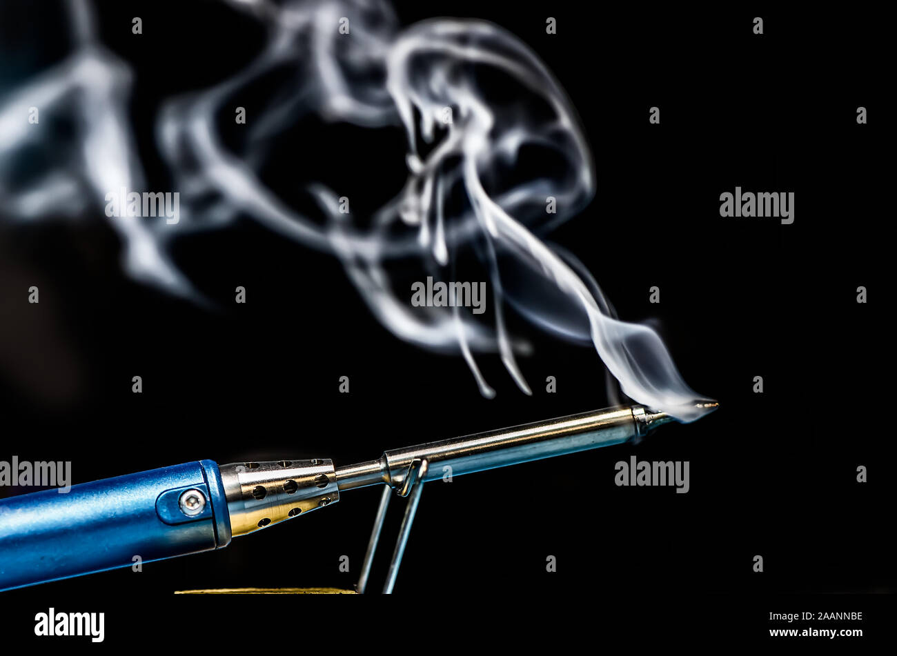 soldering iron with smoke on a black background. Electrical ...