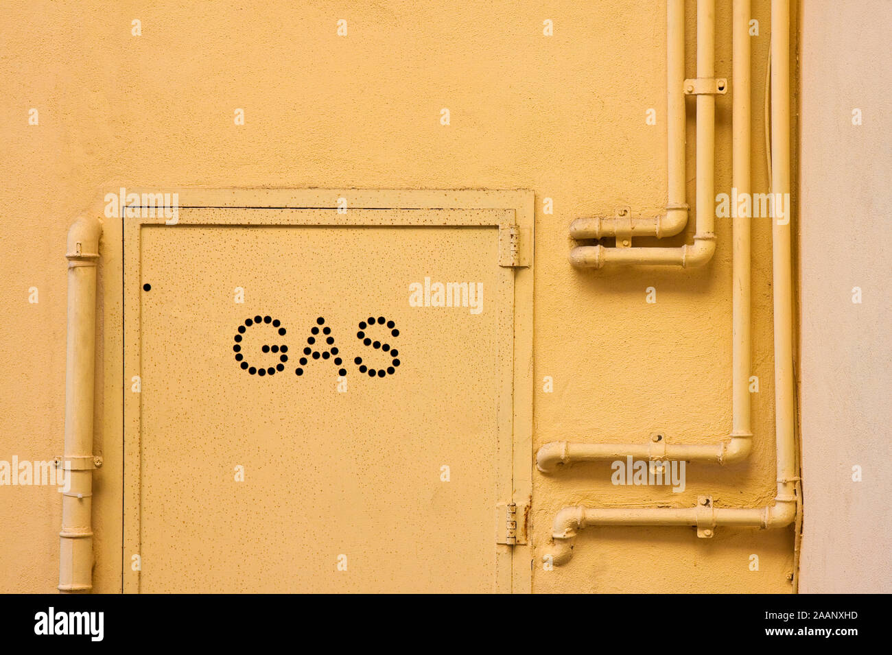 Old gas metal pipes fixed with brackets in front of a plaster wall with ...