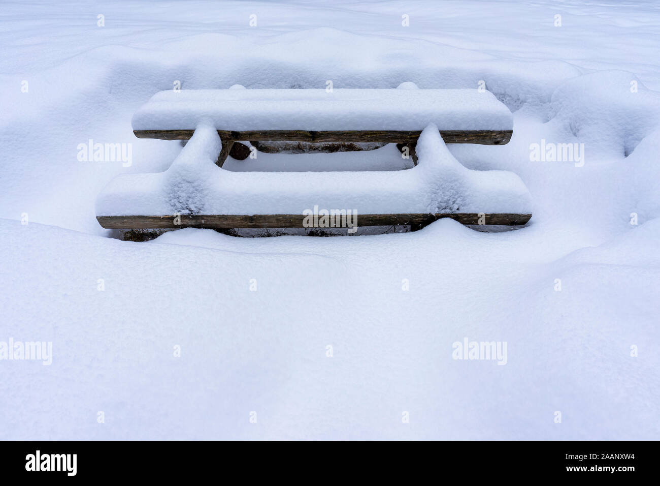 Table with a bench under the snow Stock Photo - Alamy