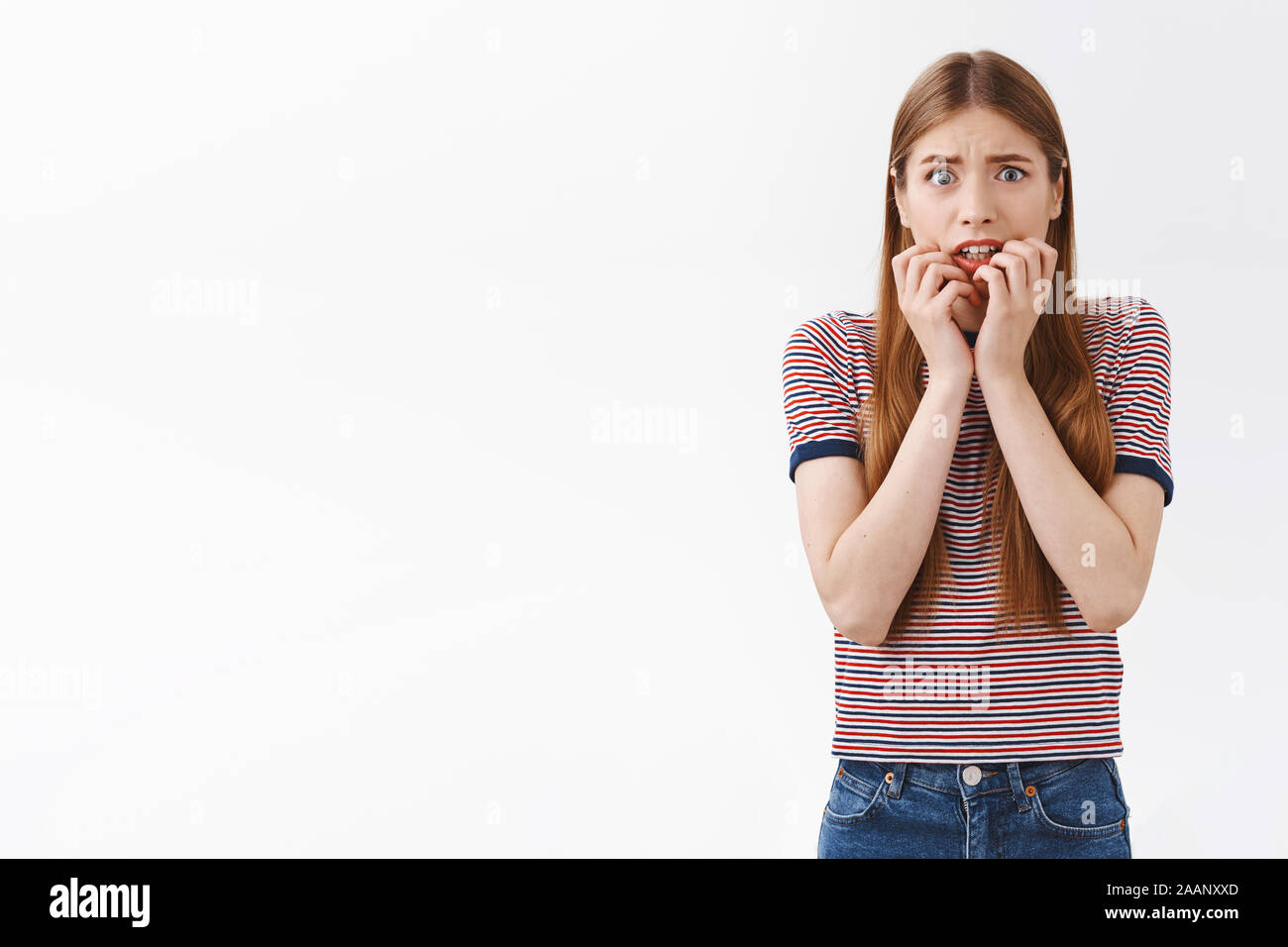 Scared innocent young girl freaking-out, bite fingernails and look ...