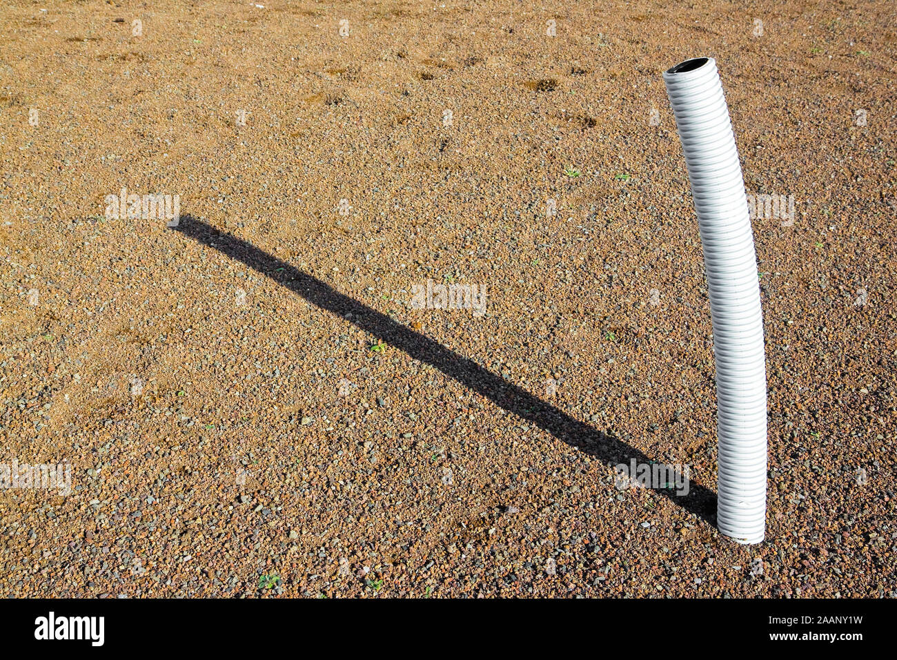Corrugated pipe with cable coming out from the ground Stock Photo - Alamy