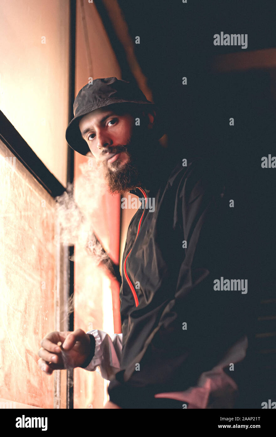 Bearded hipster smokes a cigarette at night urban style. Stock photo ...