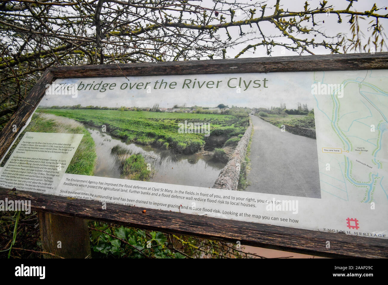An information board with an image showing a bridge and grassy fields ...
