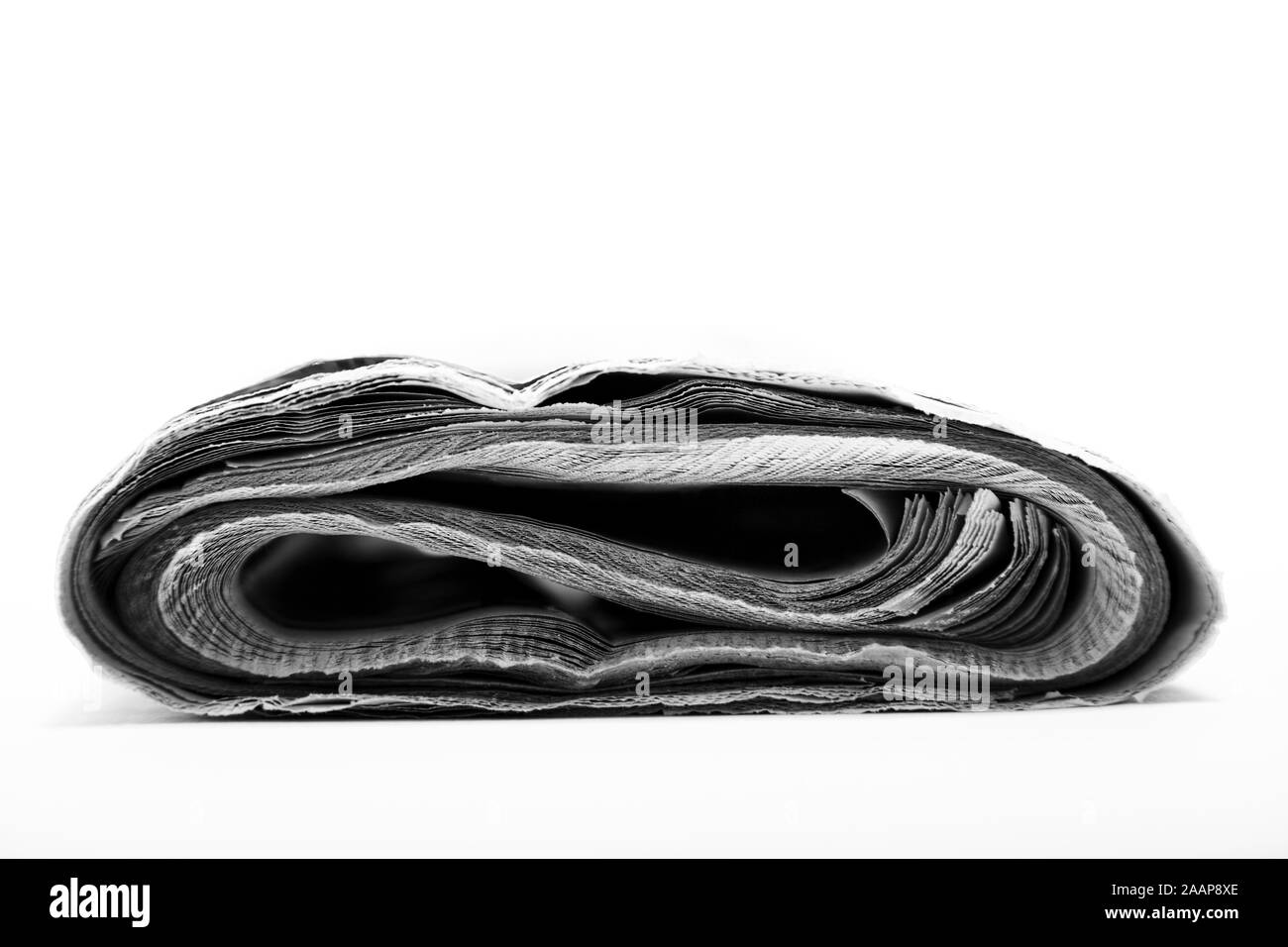 Sideways view of a rolled up newspaper isolated on a white background ...